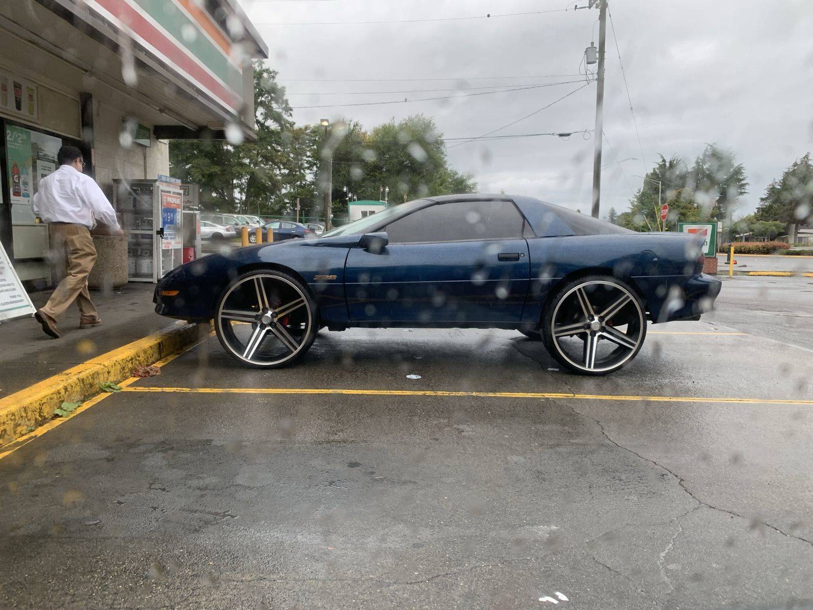 car with epic rims in the rain - MyConfinedSpace