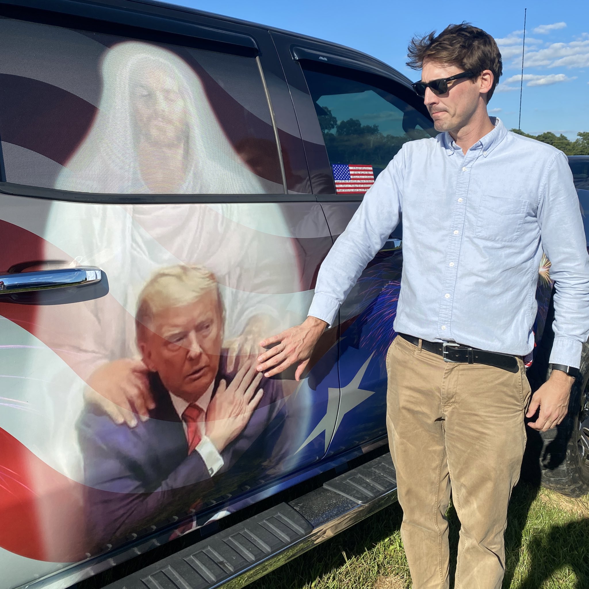 Jason Selvig in front of truck with painting that looks like Trump ...