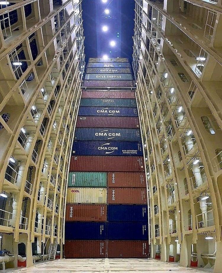 Towering stack of shipping containers, in a ship. - MyConfinedSpace